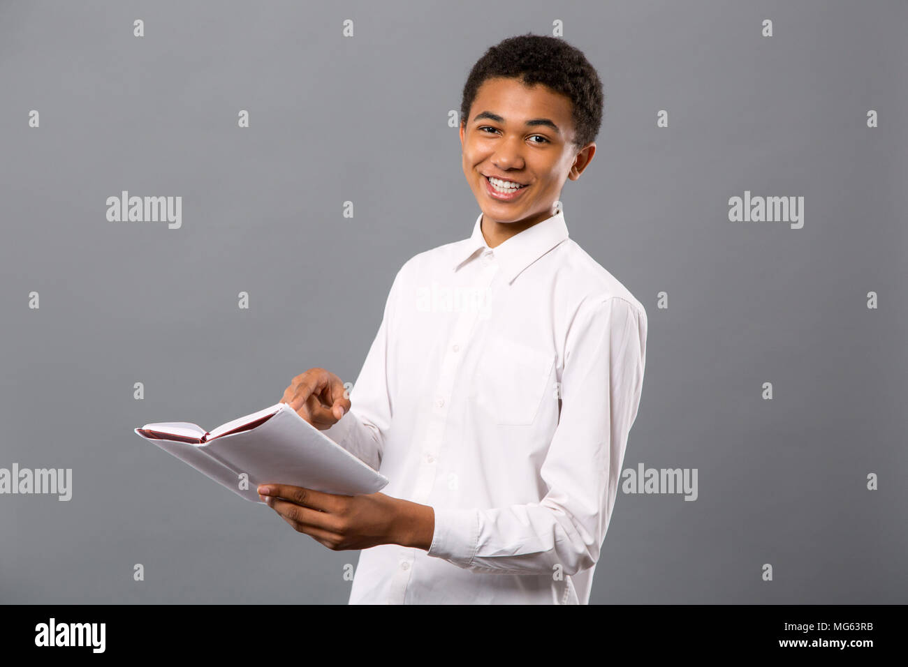Delighted smart student reading a book Stock Photo - Alamy