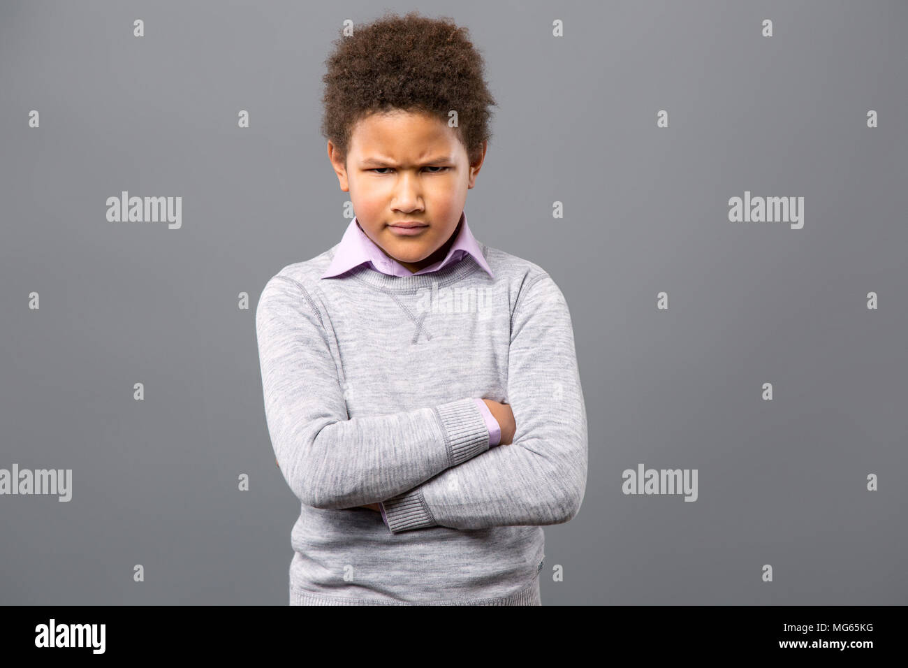 Nice young boy standing cross handed Stock Photo - Alamy