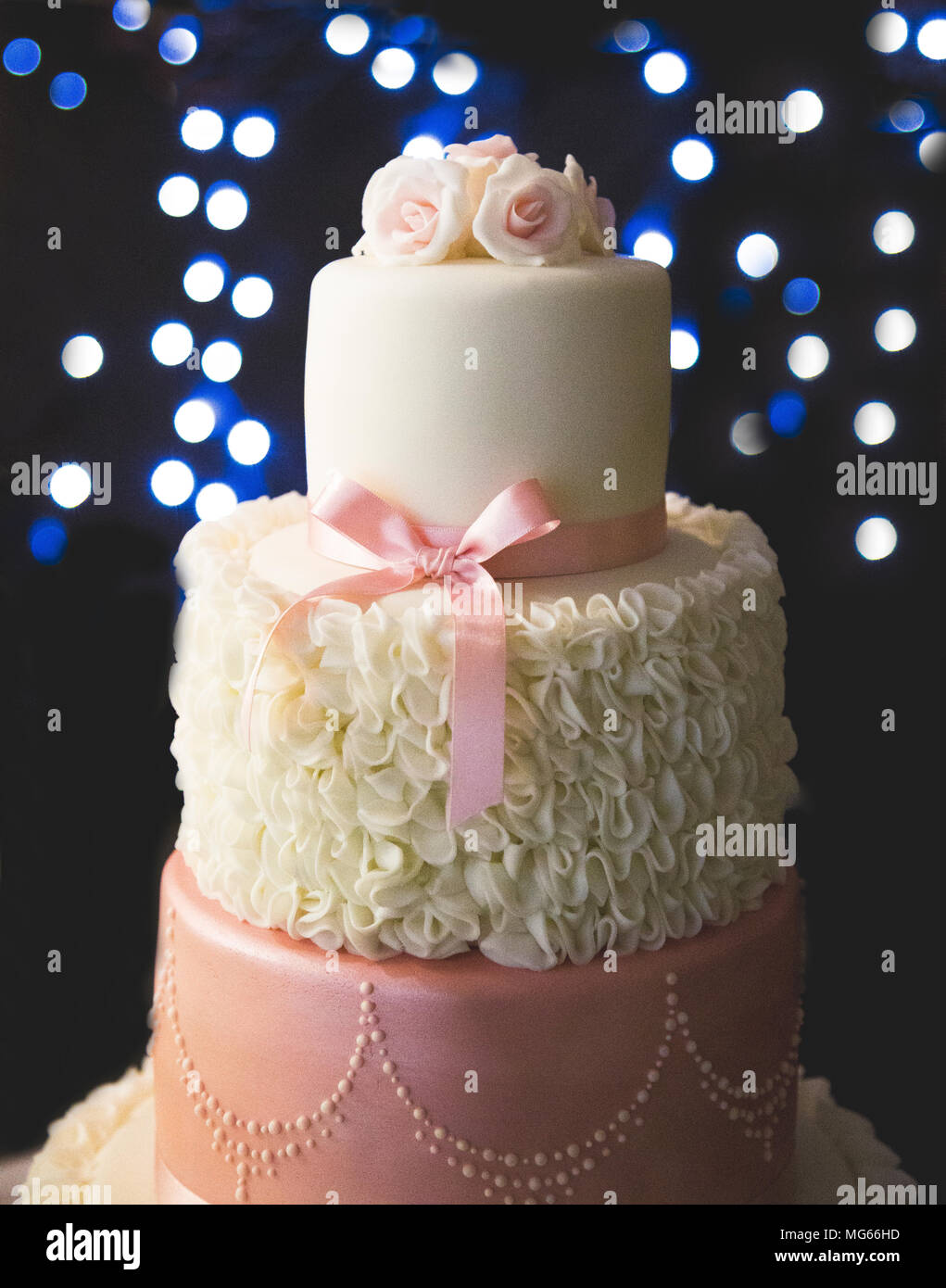 Pink and White wedding tier cake with on black background and ...