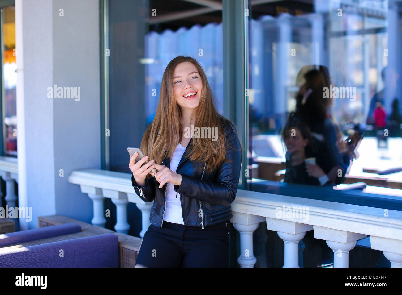 Jocund woman typing by smartphone at street cafe. Concept of enjoying ...