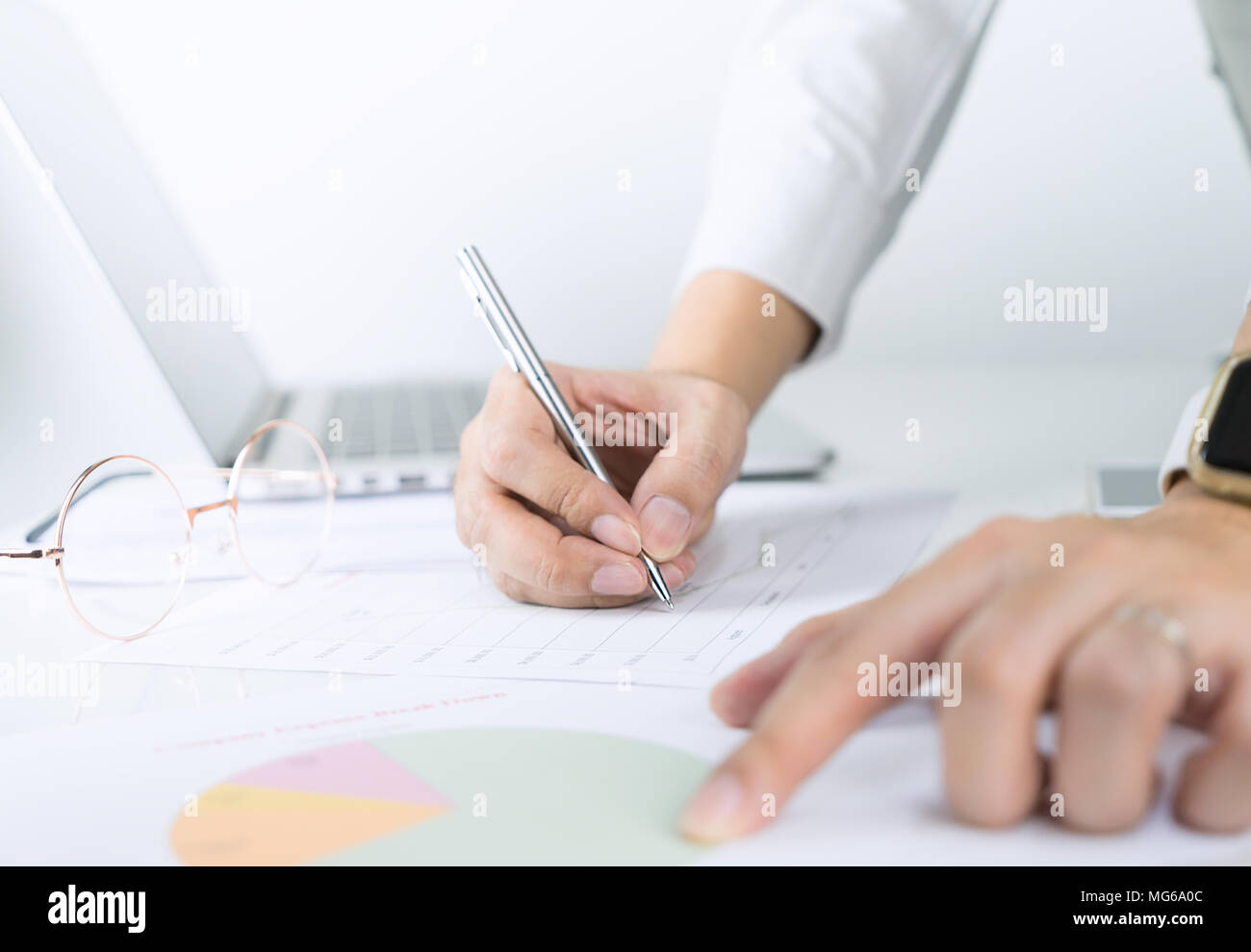 Office worker is pointing and analyzing paper chart infomation for ...
