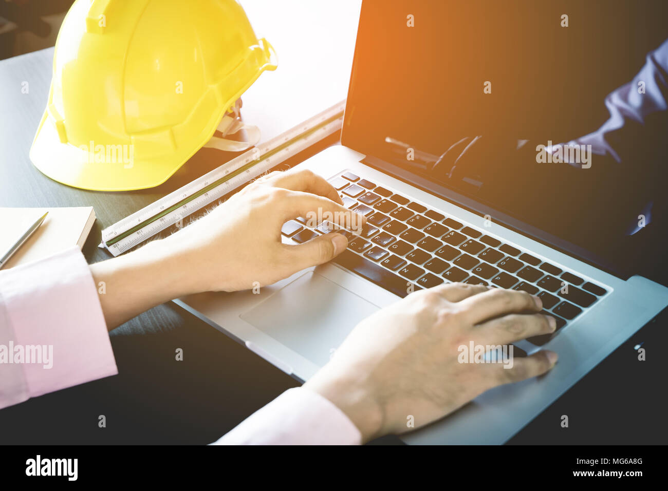 Engineer is working on computer with computer and safety helmet in ...