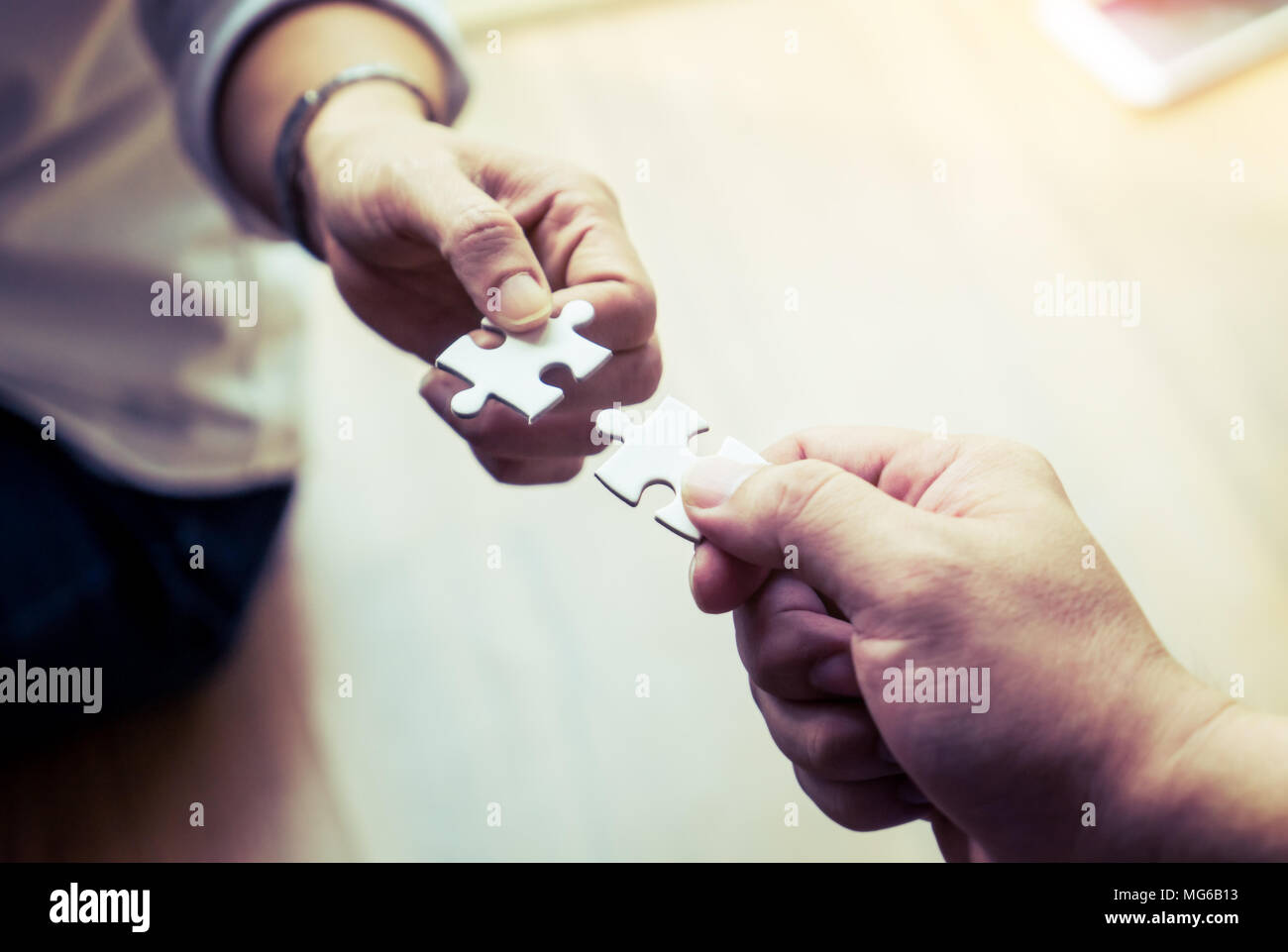 Hands joining jigsaw puzzles hi-res stock photography and images - Alamy