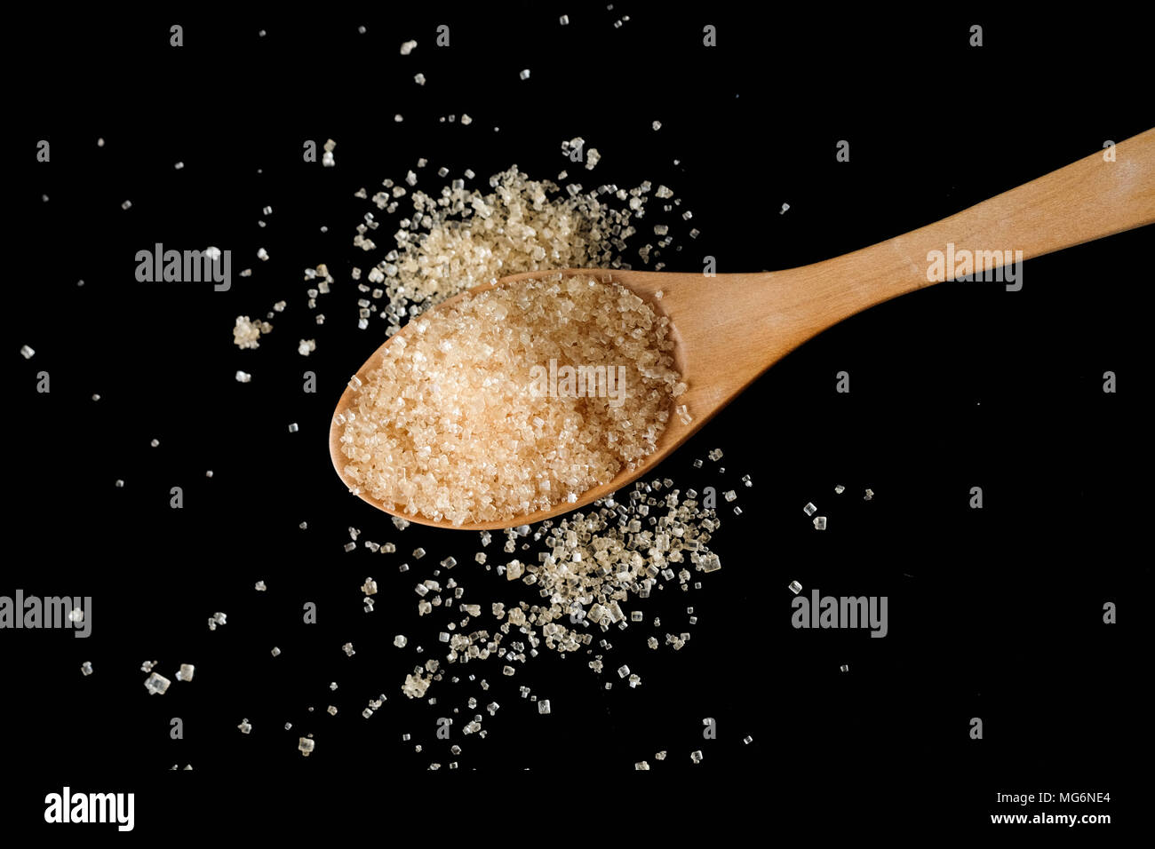 Brown sugar in wood spoon on black background.Components of The food is ...