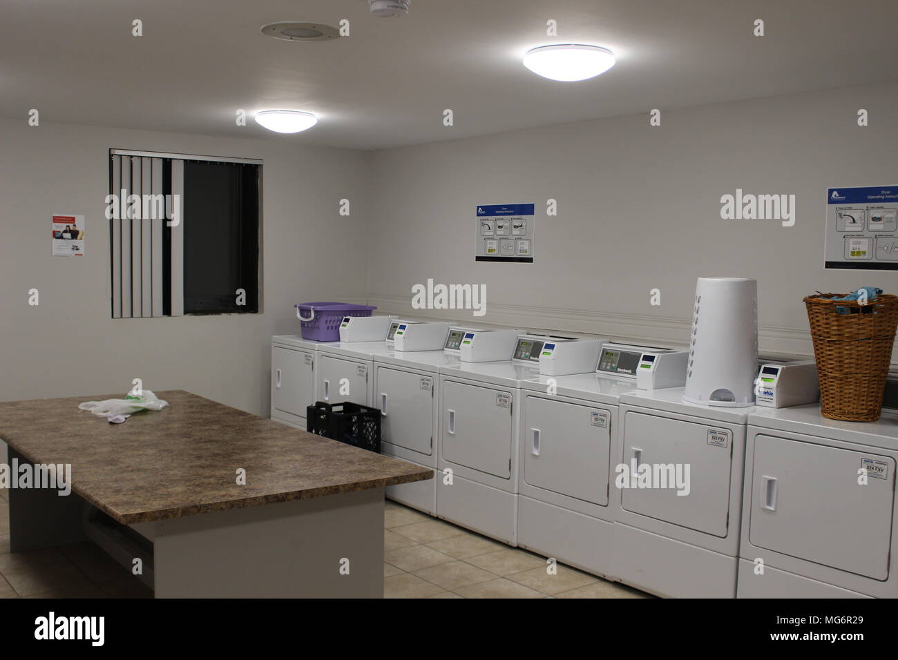 Powerful laundry machines and automatic dryers in big laundromat with a ...