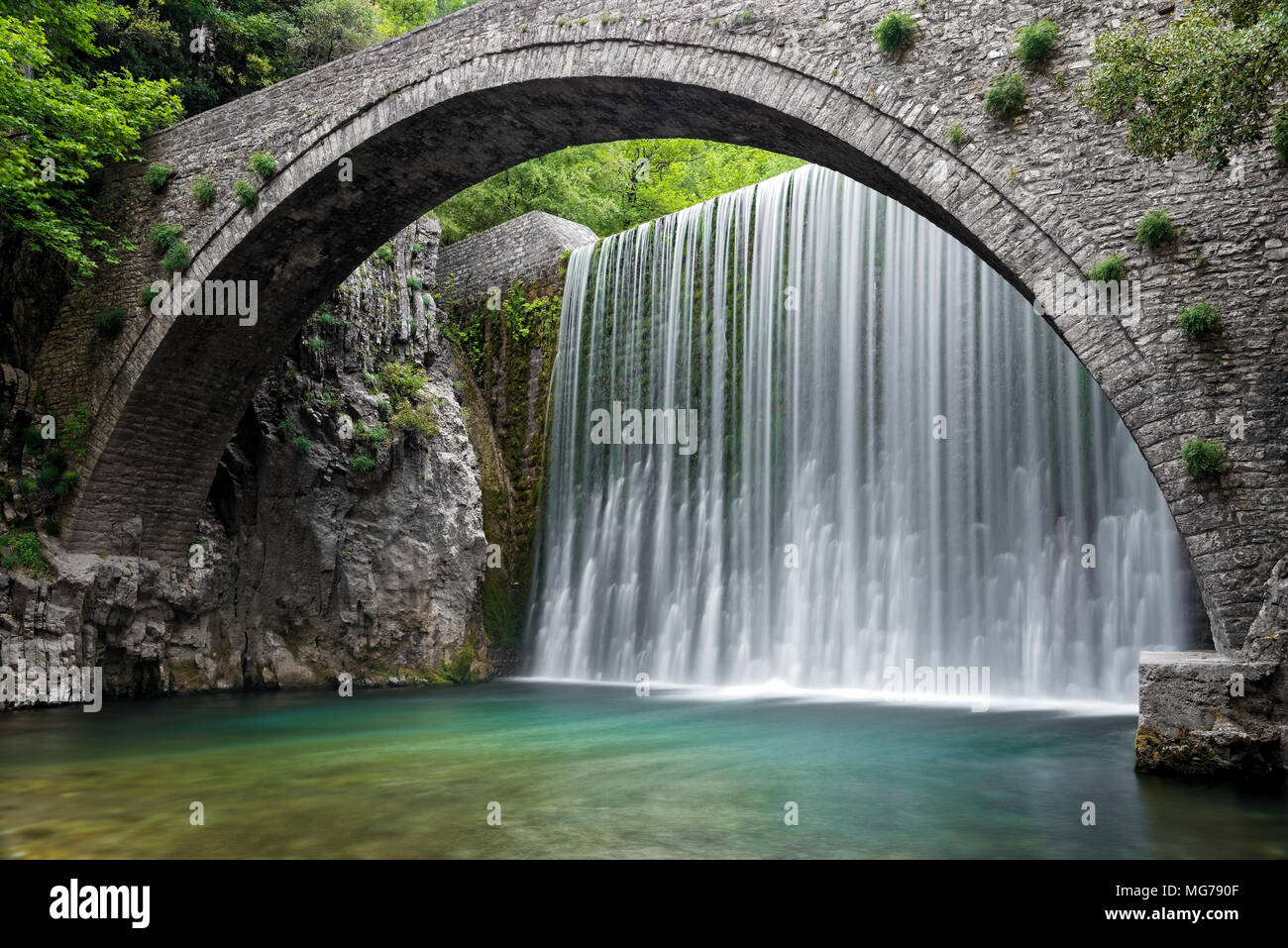 Traditional stone bridge and waterfall near Paleokaria village in ...