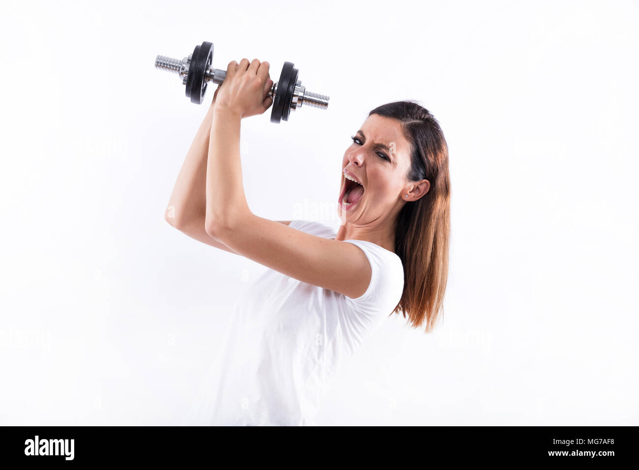 A beautiful young woman lifting weight and screaming Stock Photo - Alamy