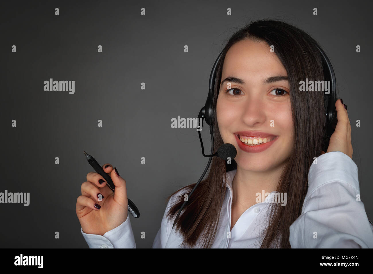 Beautiful smiling Turkish female call center girl keeping a pen on her ...