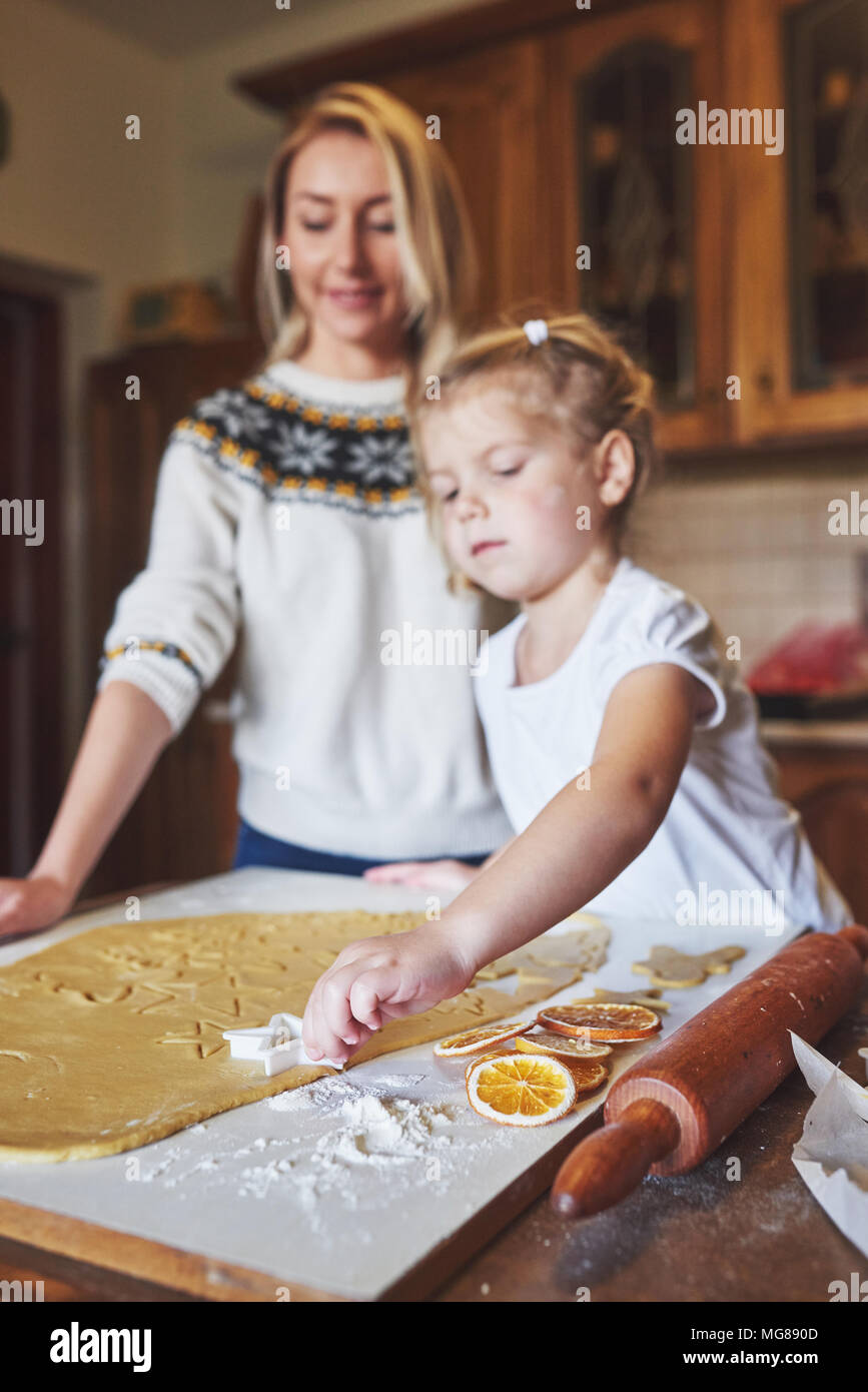 Happy girl with her mother cook cookies Stock Photo - Alamy