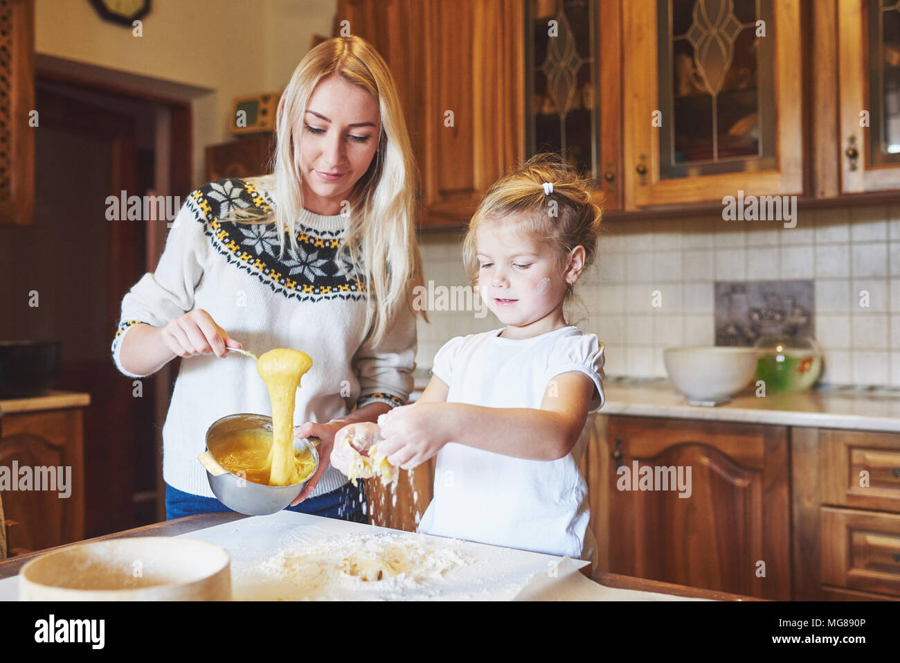 Happy smiling mom in the kitchen bakes cookies with her daughter Stock ...