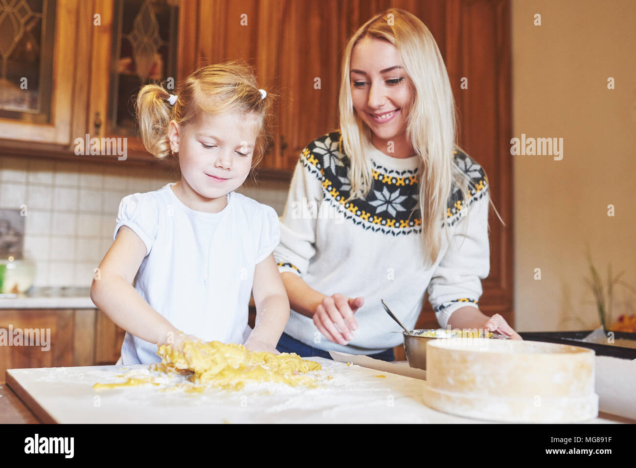 Happy smiling mom in the kitchen bakes cookies with her daughter Stock ...