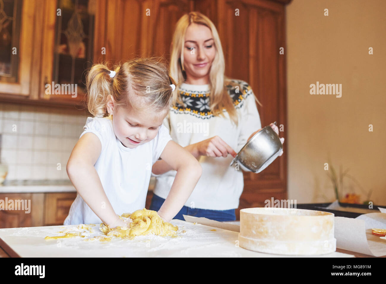 Happy smiling mom in the kitchen bakes cookies with her daughter Stock ...