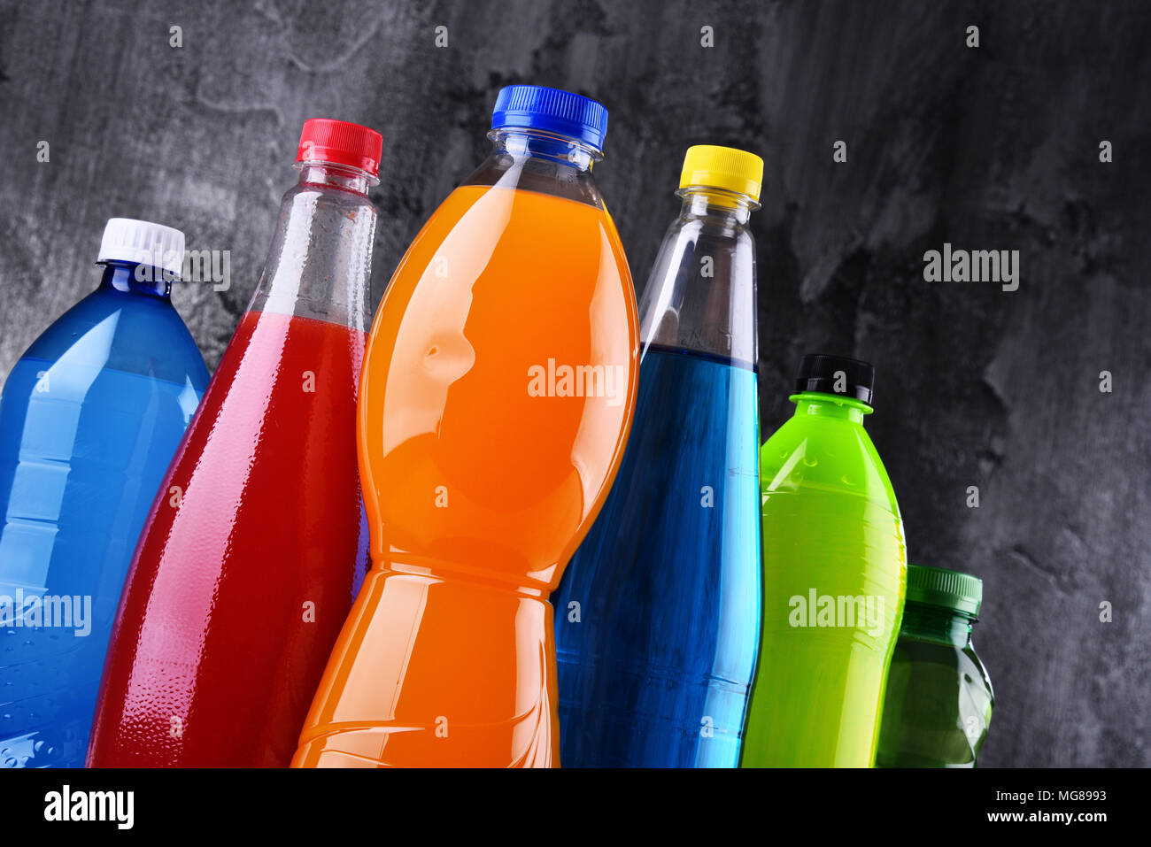 Plastic bottles of assorted carbonated soft drinks in variety of colors ...