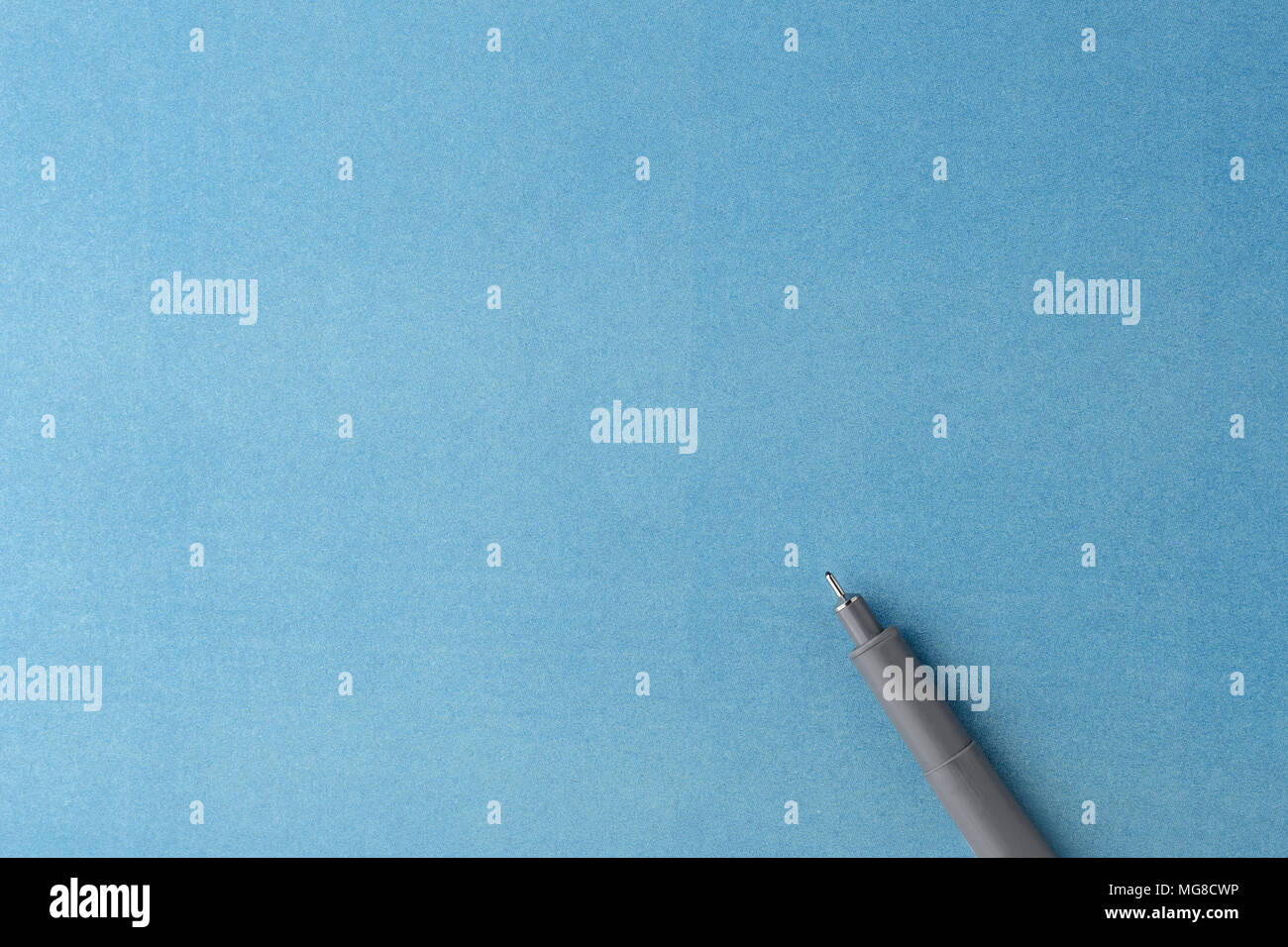 gray pen on blue blank sheet of paper as background Stock Photo - Alamy