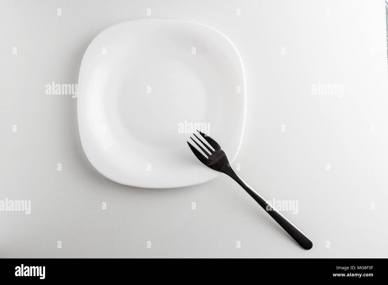 empty white plate and fork on a white background. View from above Stock ...