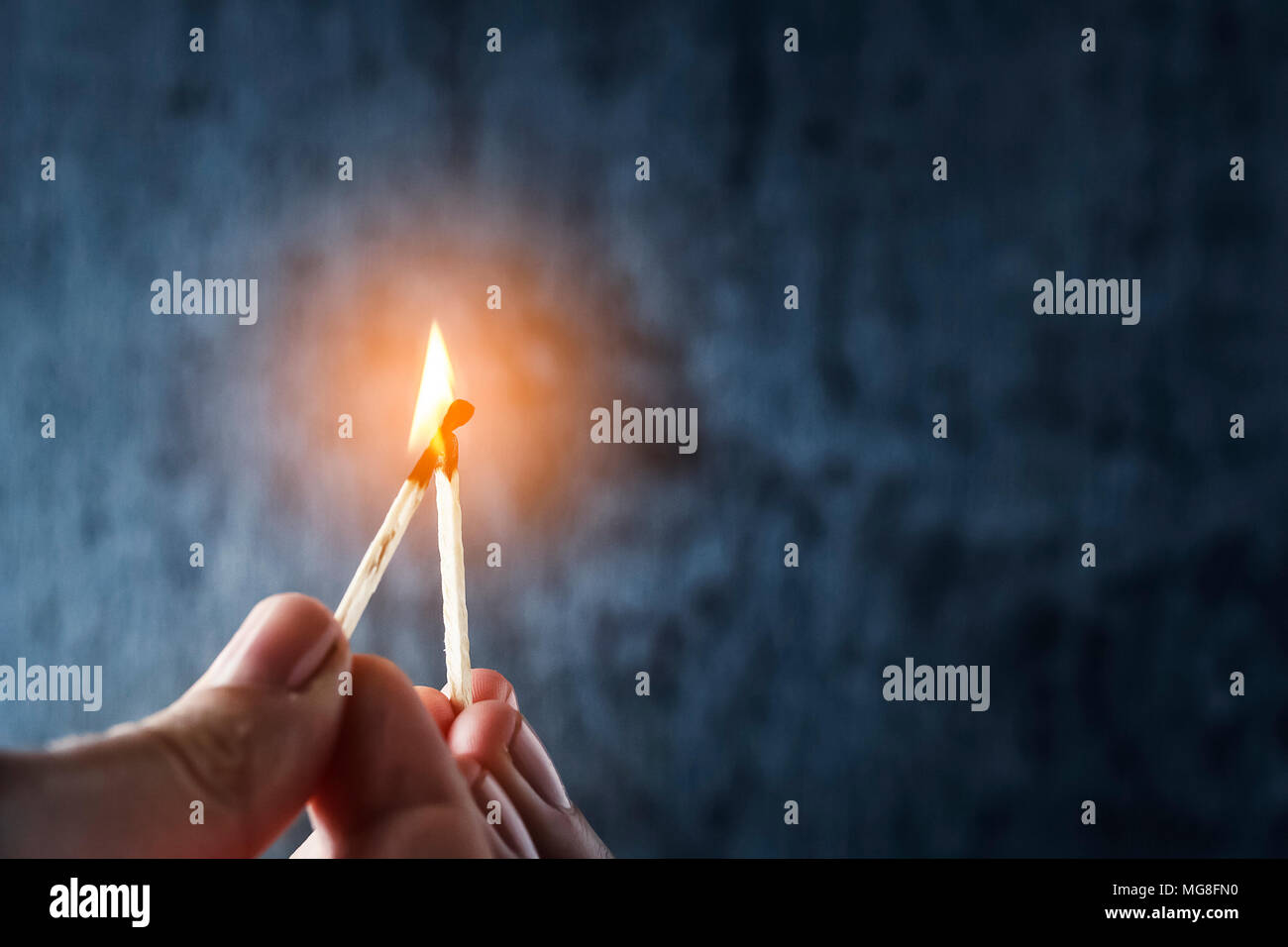 One match sets the other on fire. Fire from matches on a dark blue ...