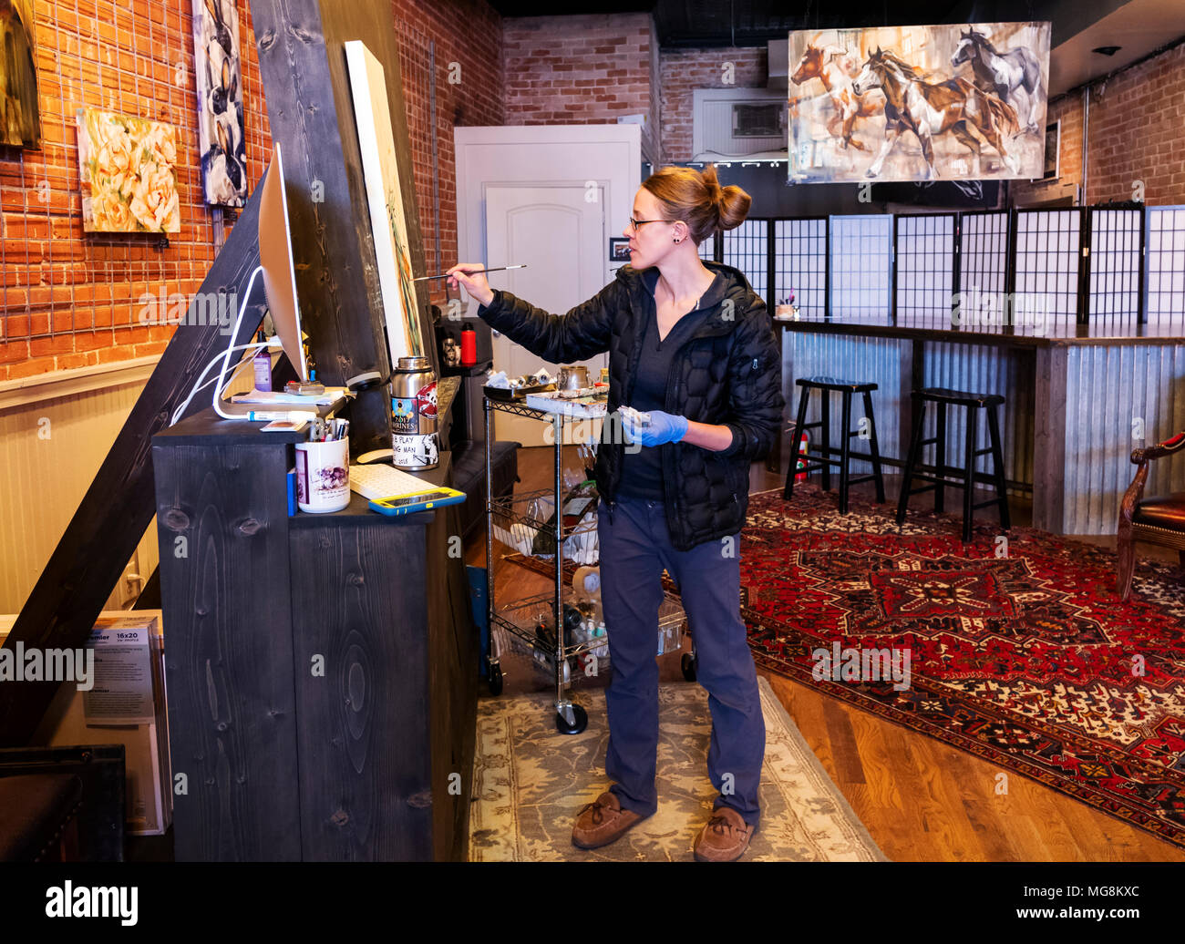 Fine artist Katie Maher creating an oil painting in her gallery; Salida ...