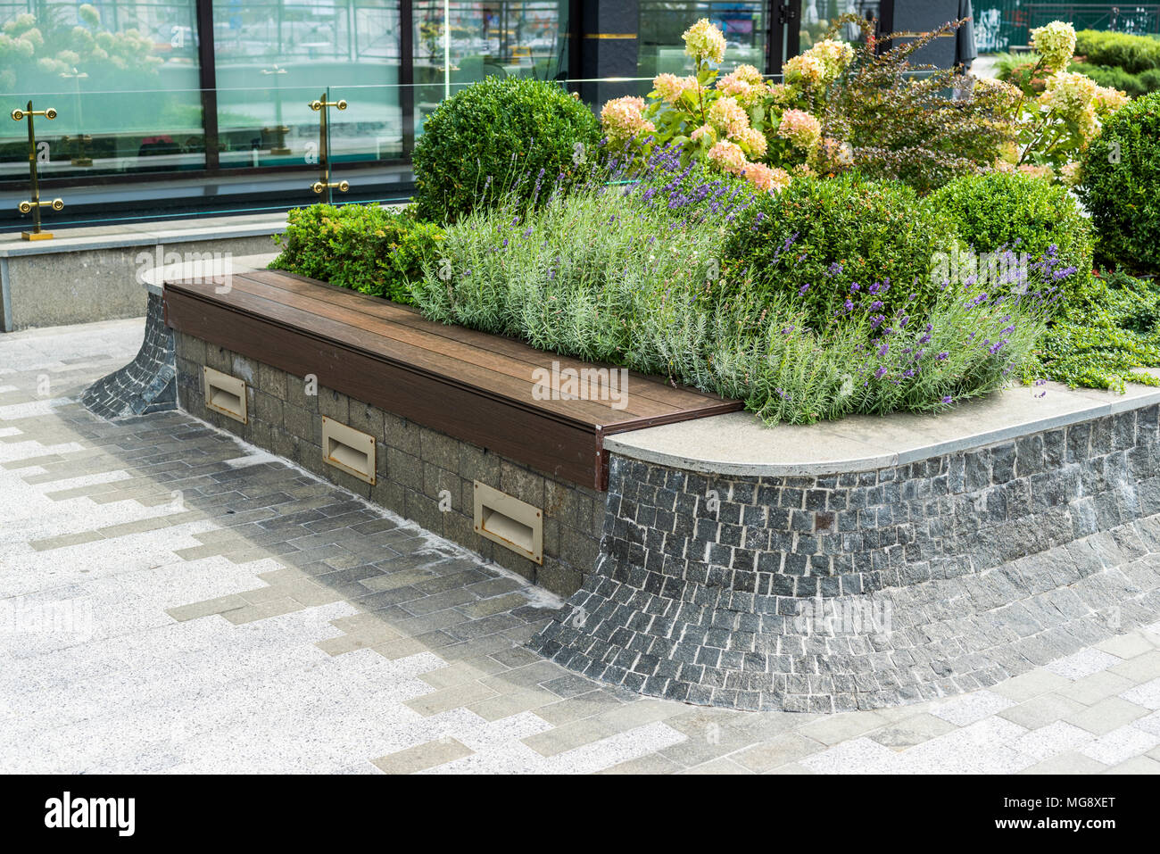 Wooden seat by the flower bed Stock Photo - Alamy