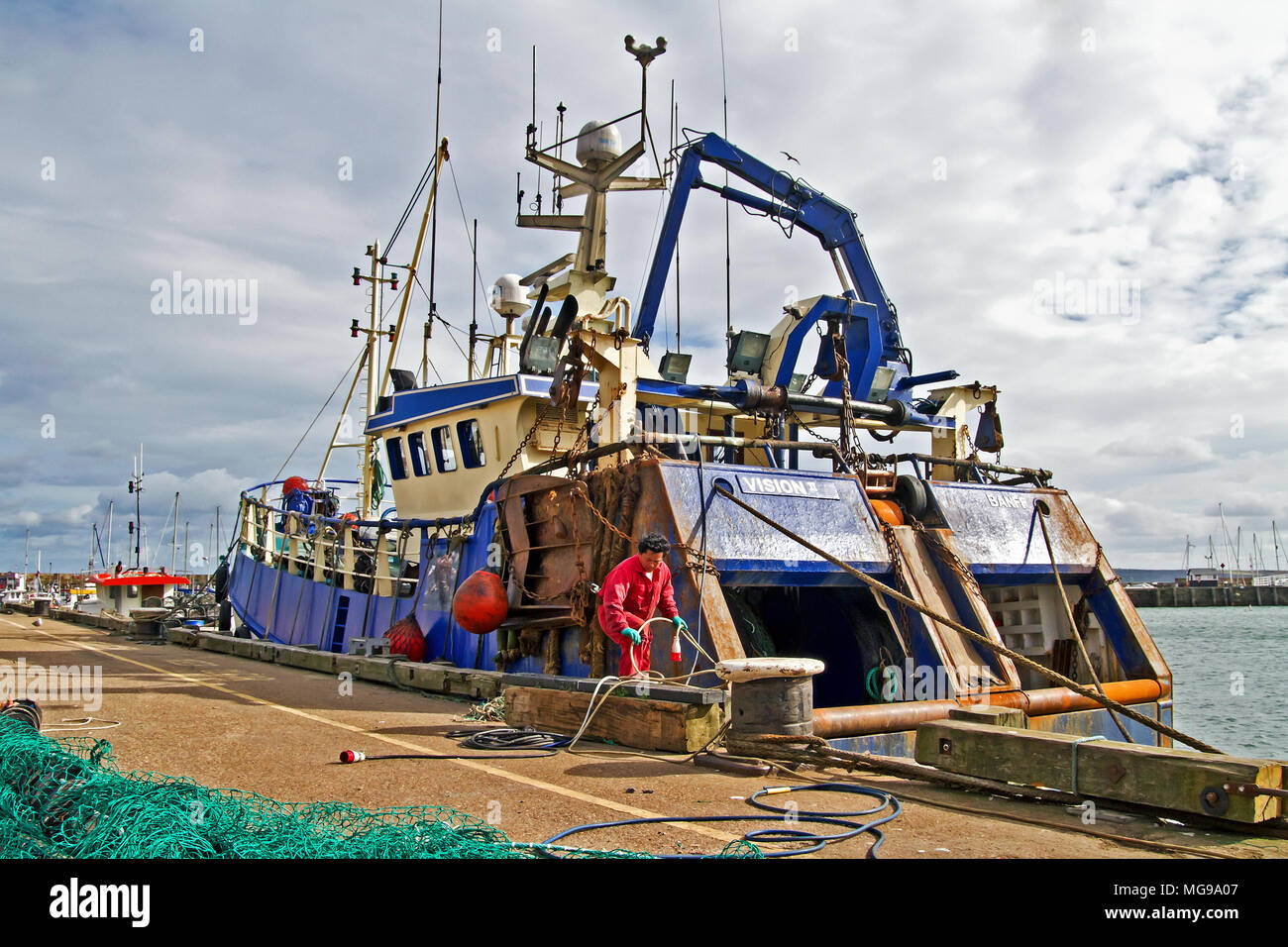 Dockside maintenance work for a trawler moored in Scarborough harbour ...