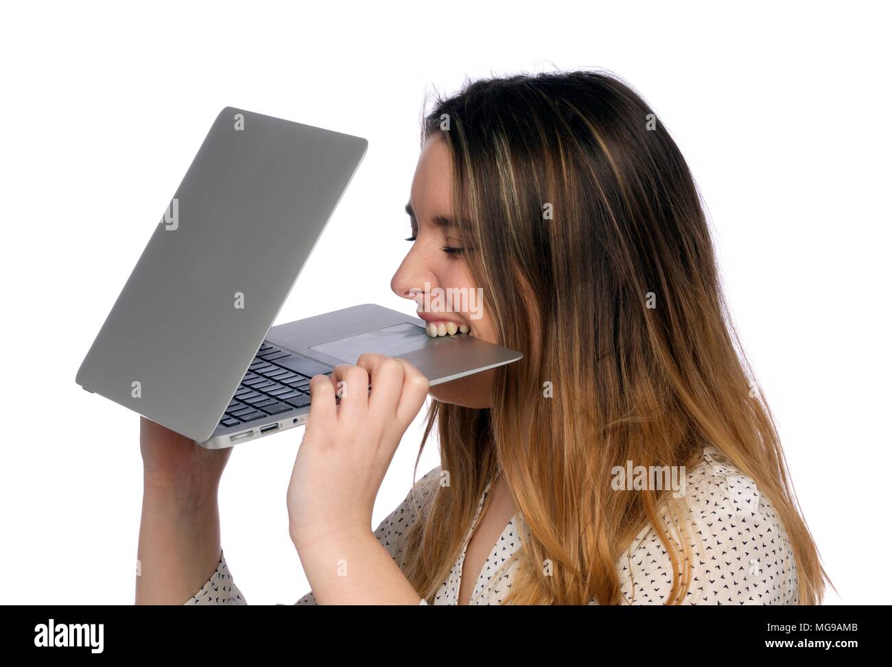 Young woman biting laptop Stock Photo - Alamy