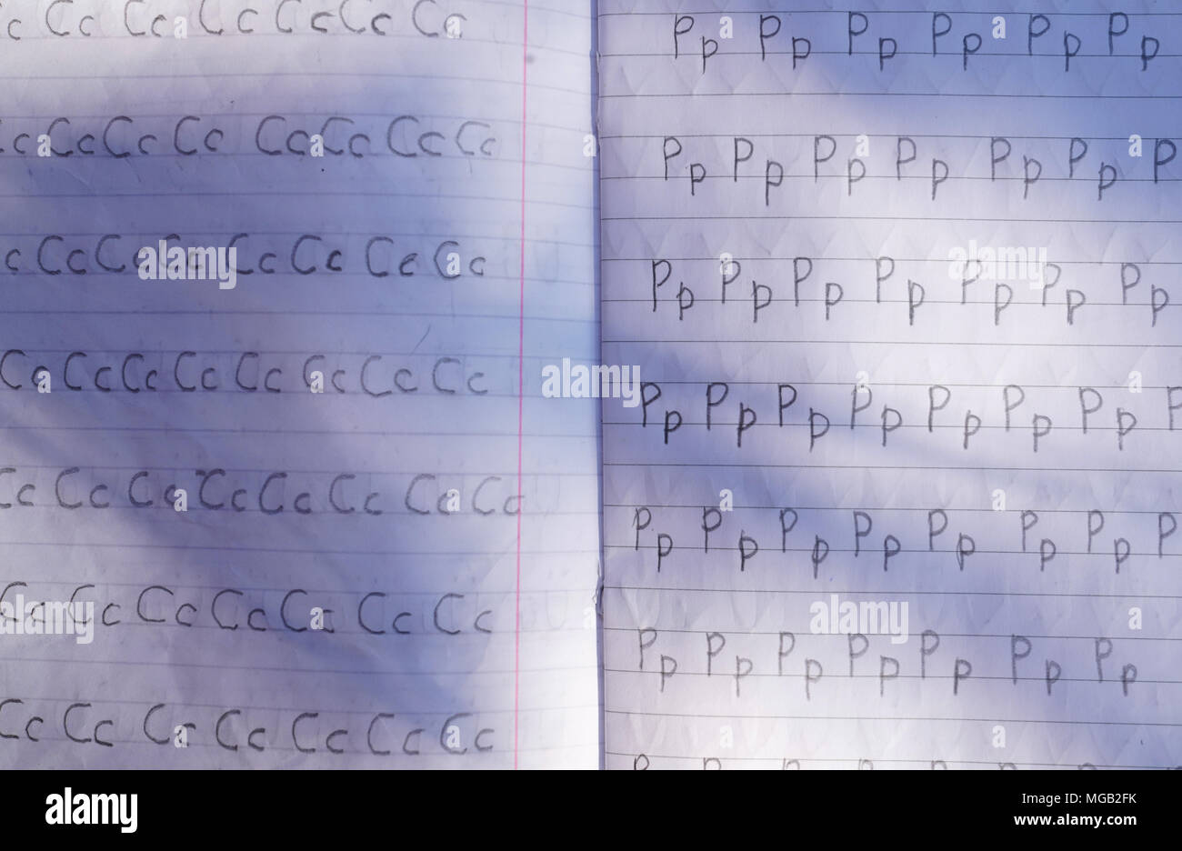 Child's hand writes in a notebook with a pencil Stock Photo - Alamy