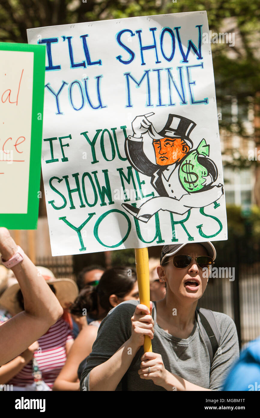 A woman holds sign that says "I'll show you mine, if you show me yours ...