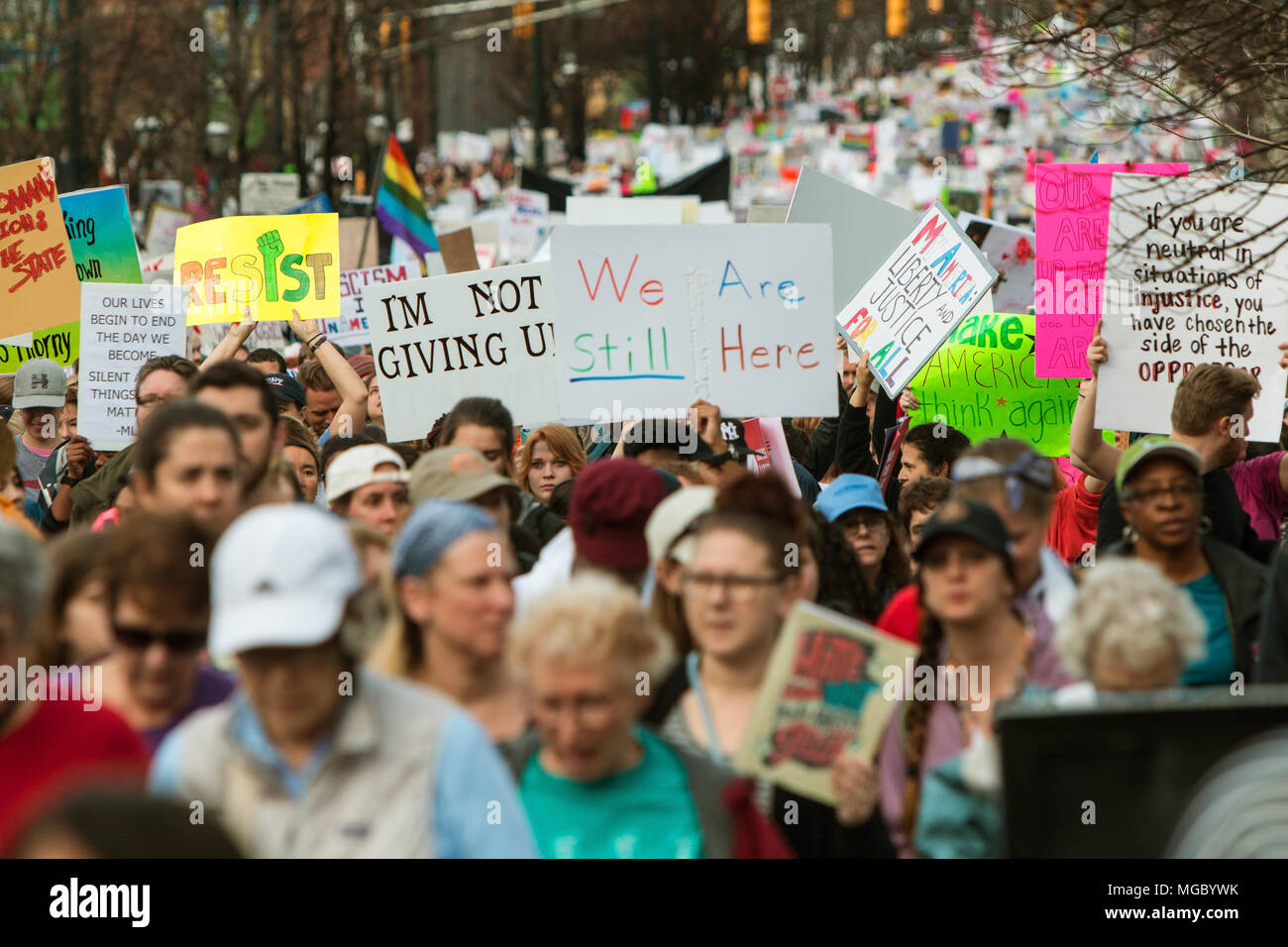A group of protest signs rise above the crowd as thousands of ...