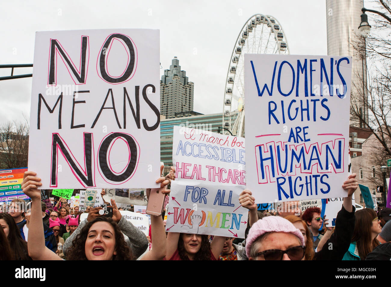 Women hold up signs in support of women's rights, as thousands of ...