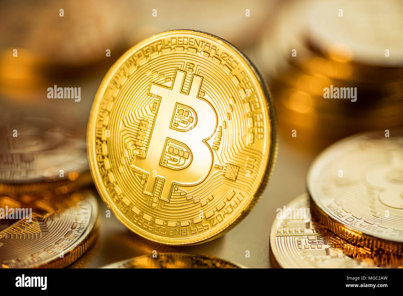 Shiny physical bitcoins on golden background. Blockchain technology ...