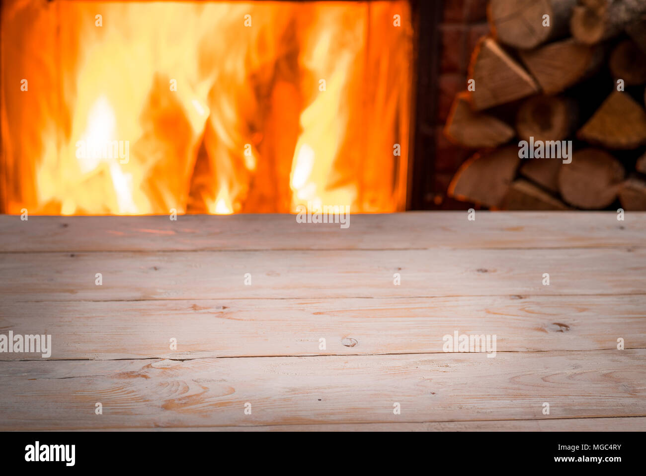 Wooden table top and burning warm fire at the background Stock Photo ...