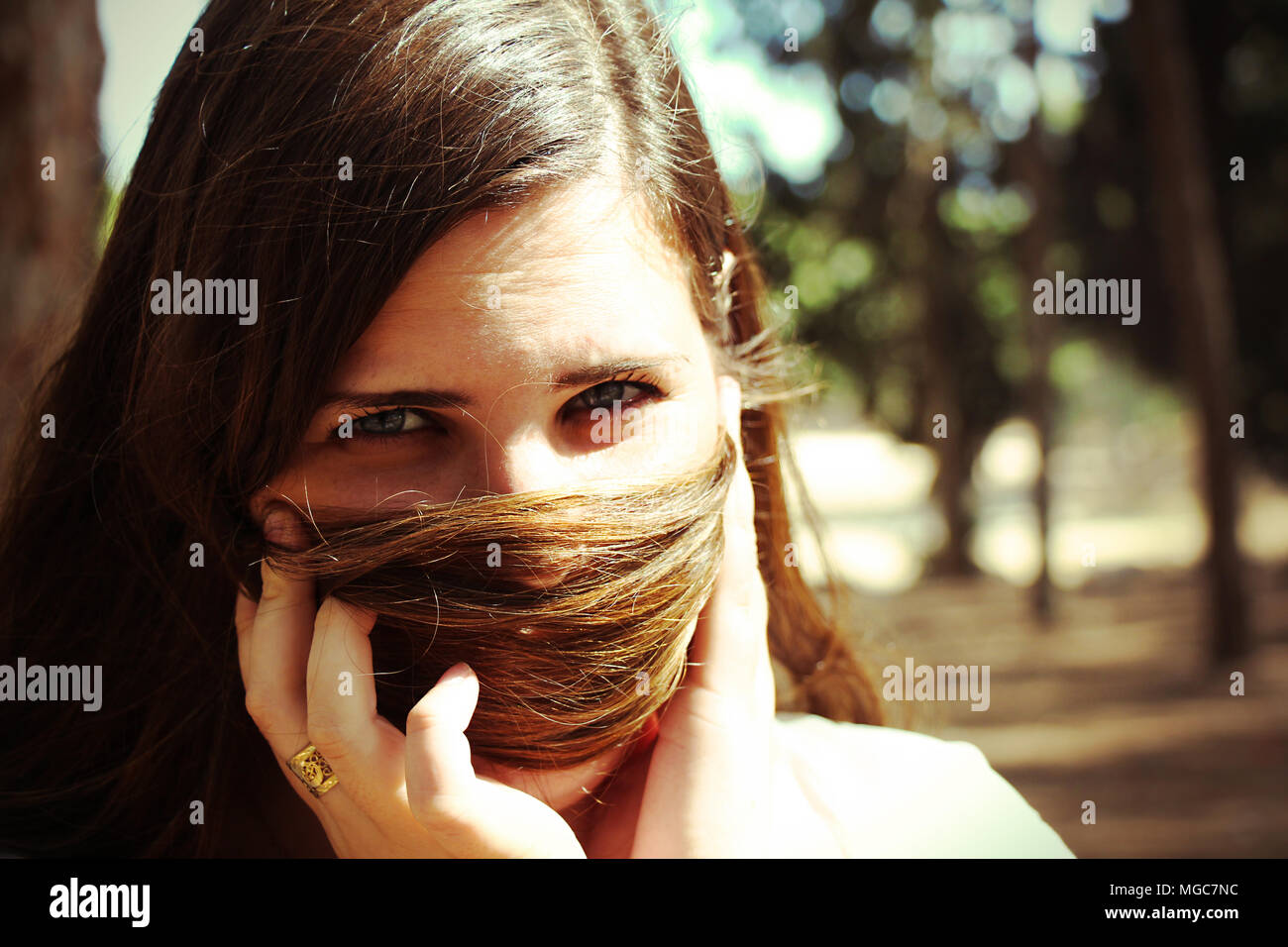 Woman hiding her face with her hair looking at camera Stock Photo - Alamy