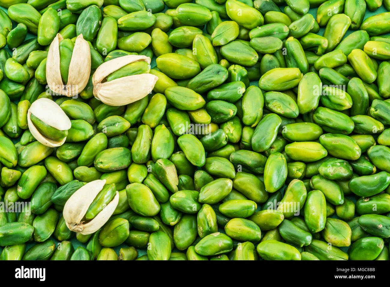 Lot of green pistachio nuts. Food background Stock Photo - Alamy