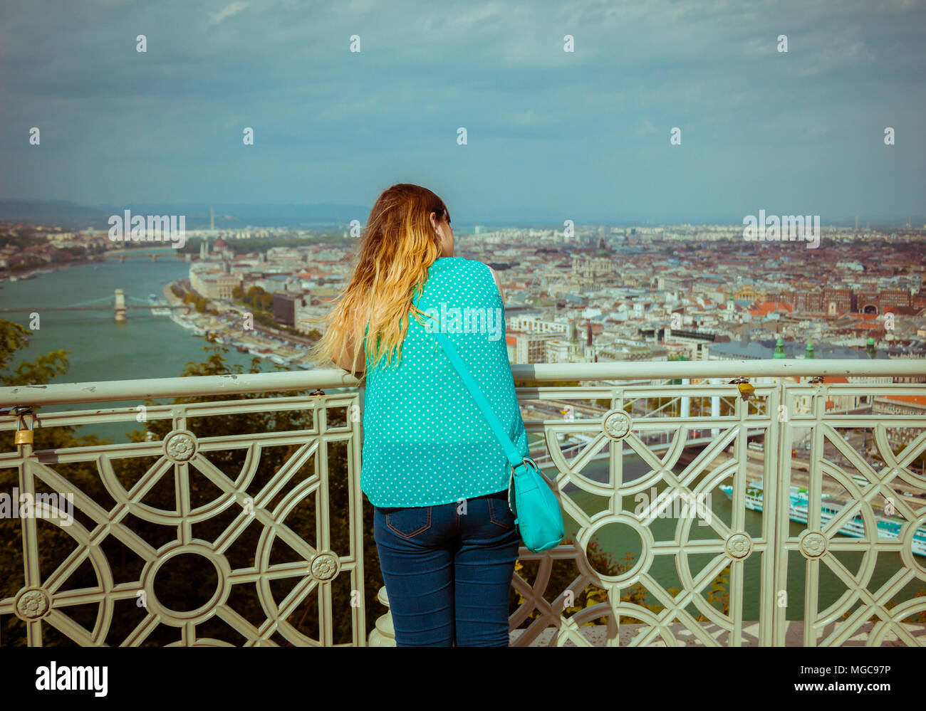 Woman leans on the railing and watching the horizon while Budapest ...