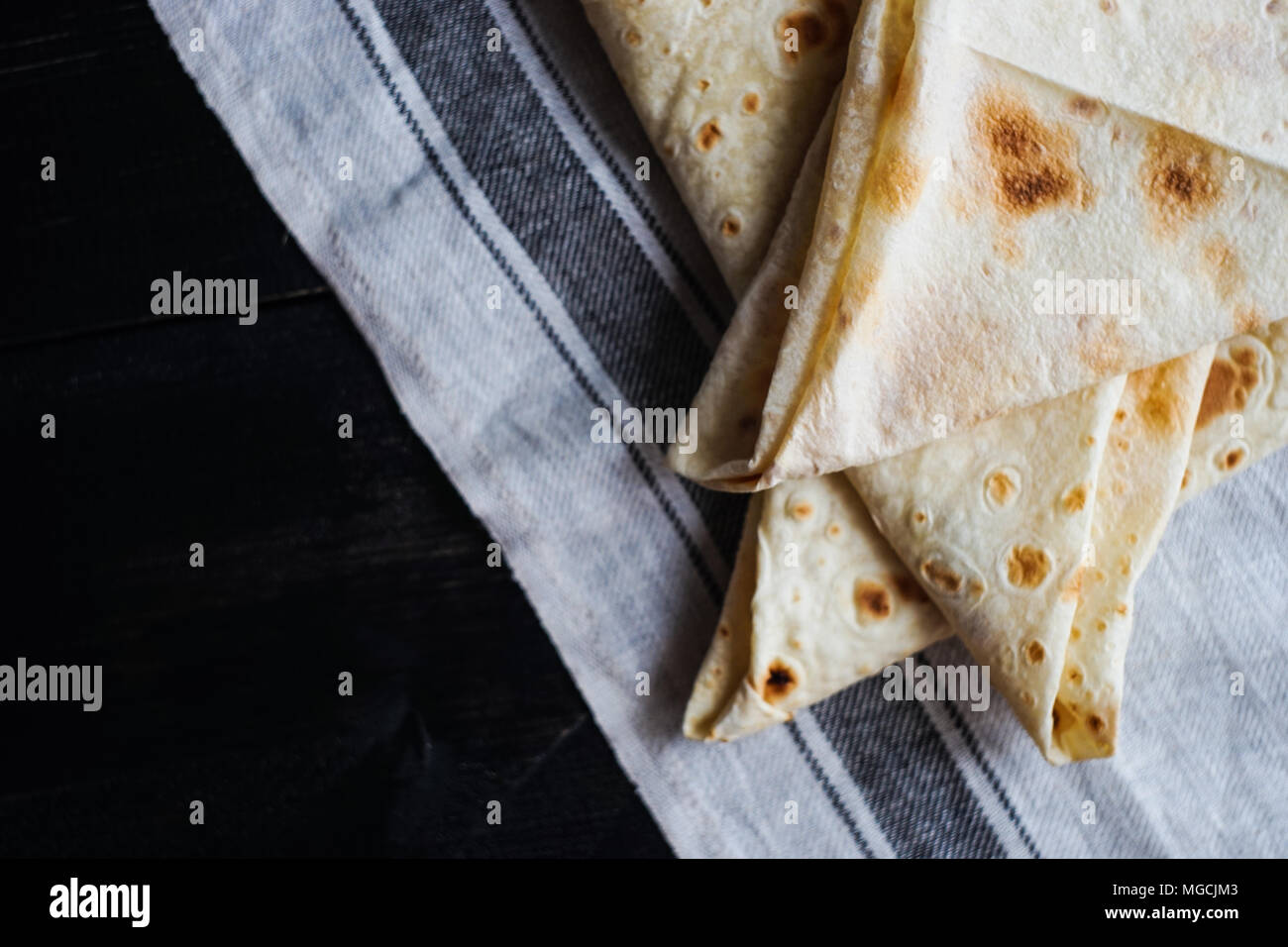 Traditional armenian flat bread - lavash on dark wooden table with ...