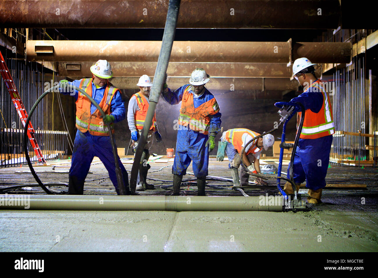 Workers placing concrete at night in the Montague Trench of the BART to ...