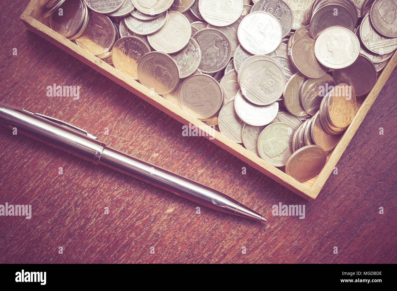 Pen and coins with filter effect retro vintage style Stock Photo - Alamy