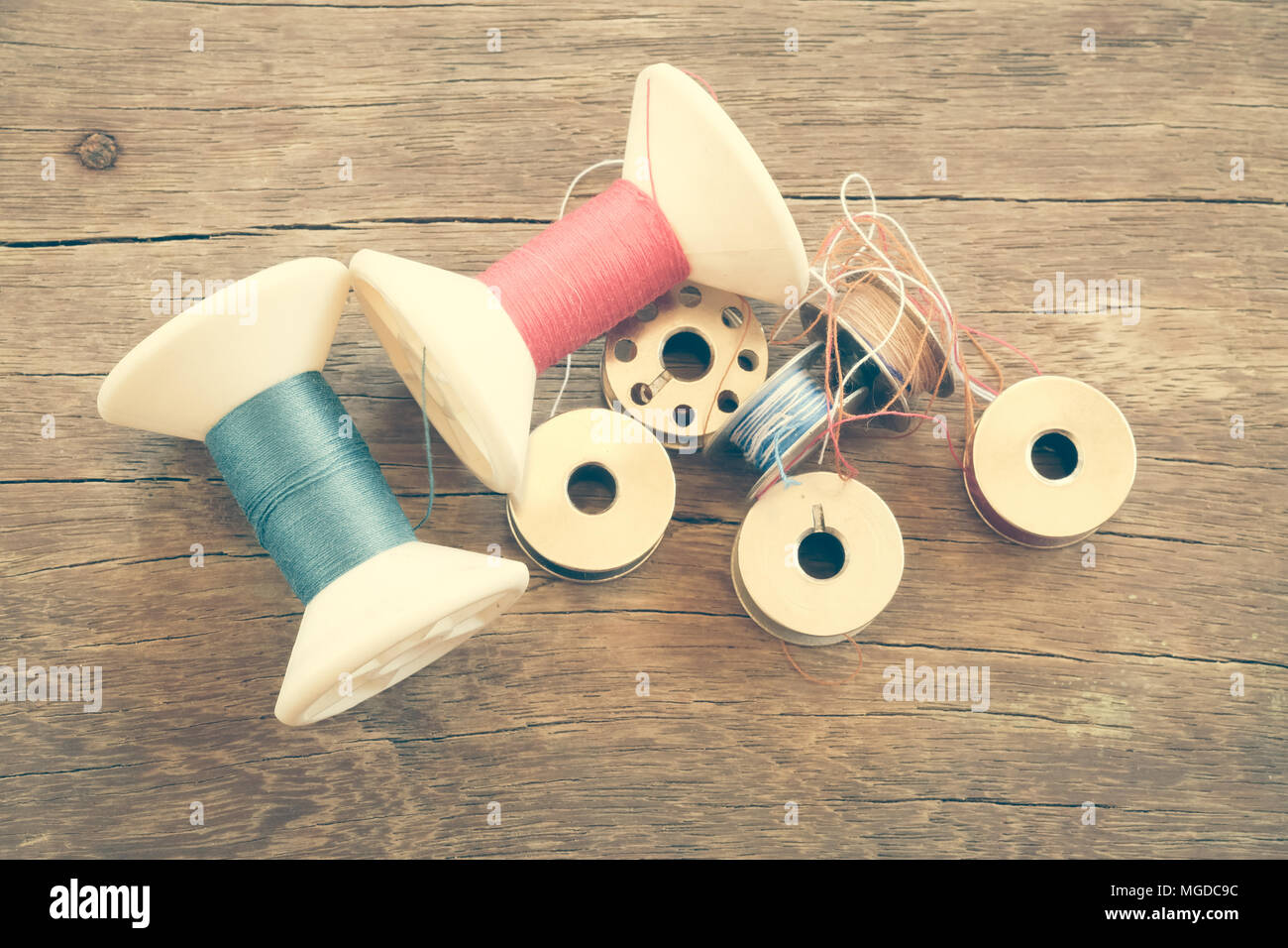 thread rolls on wood background with filter effect retro vintage style ...