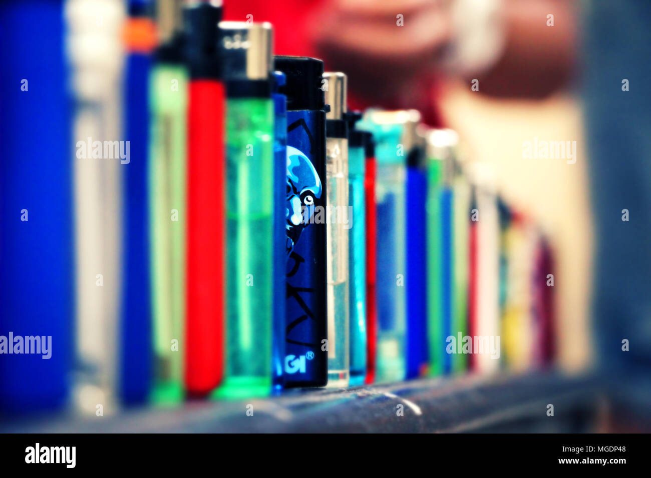 Lighters lined up. One lighter blue color stands out from the rest. Man ...
