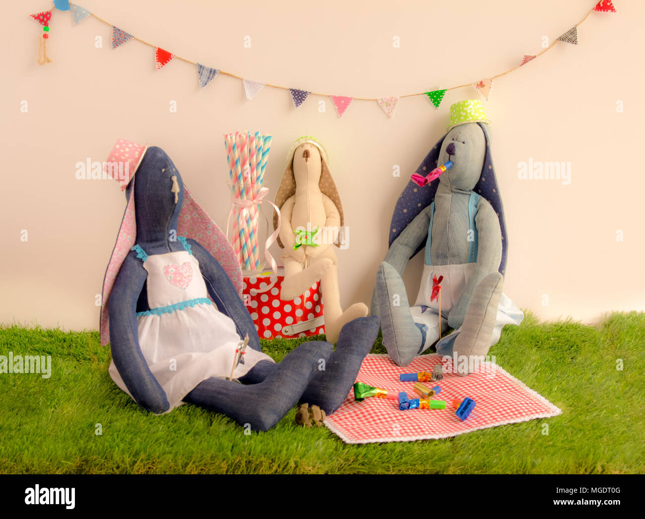 Handmade cloth rabbit dolls sitting on the grass and celebrating in ...