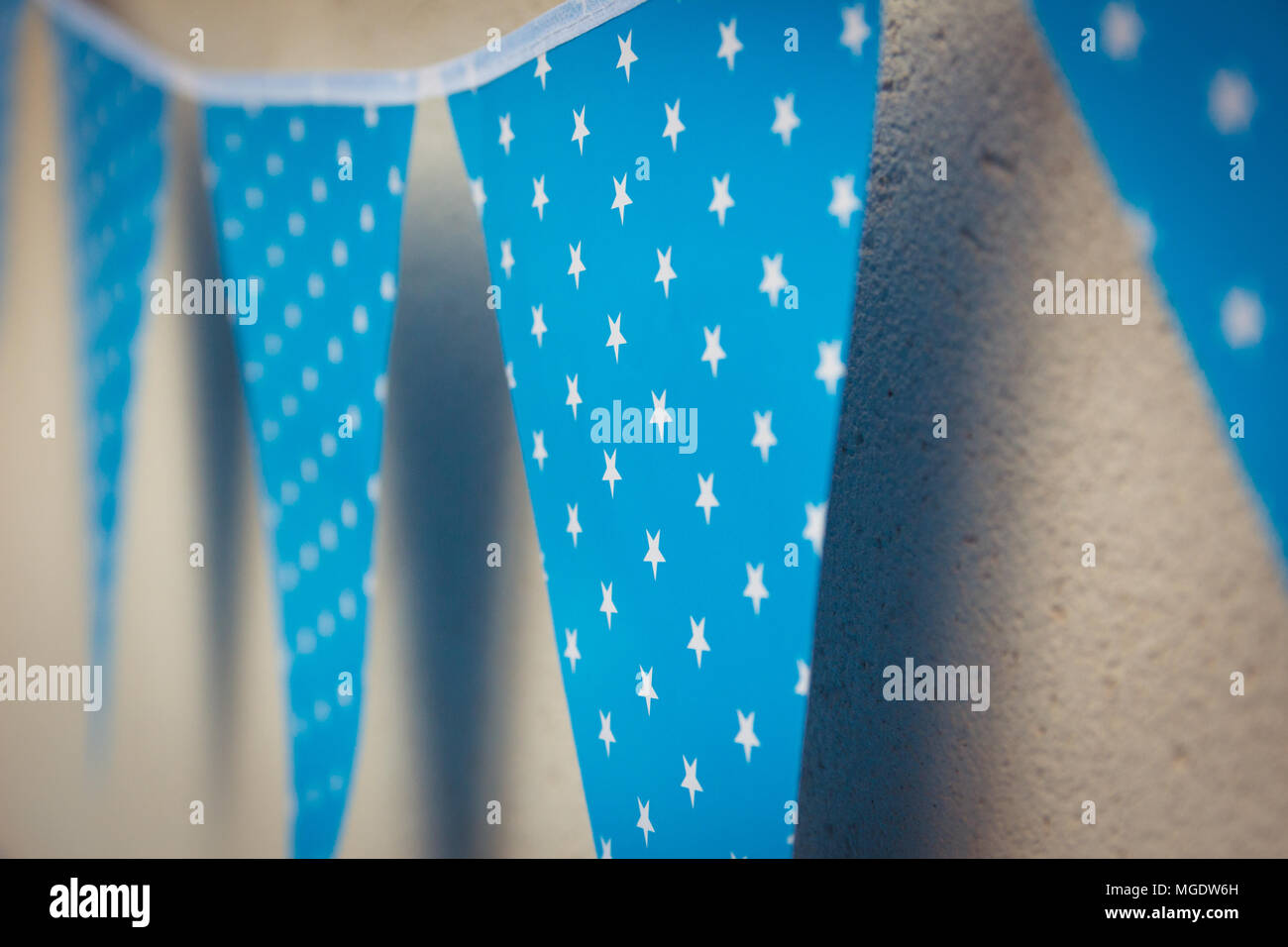 line of colorful blue party decorations flags with white stars ...