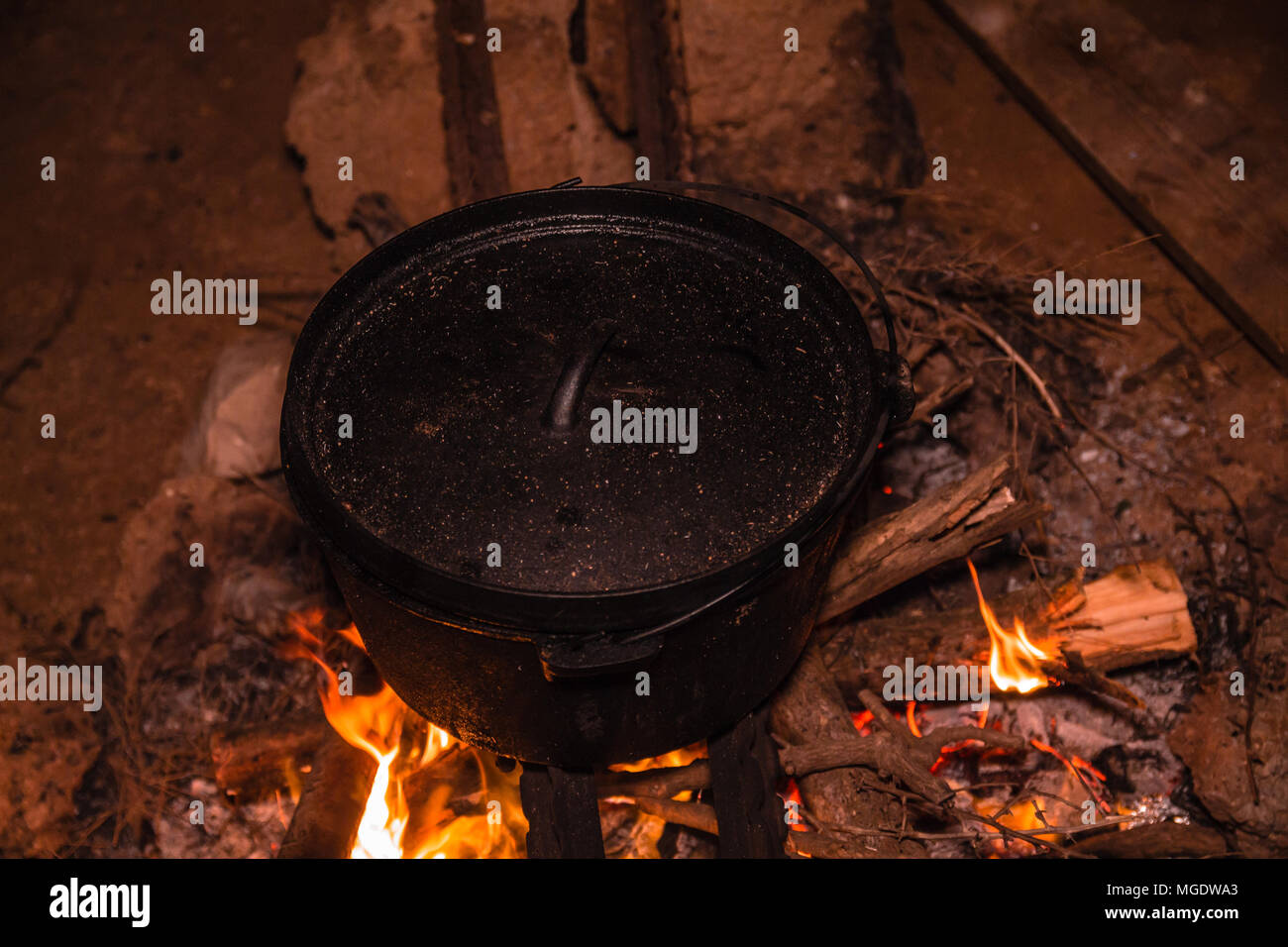 Cooking meal in cauldron on burning campfire at night Stock Photo - Alamy