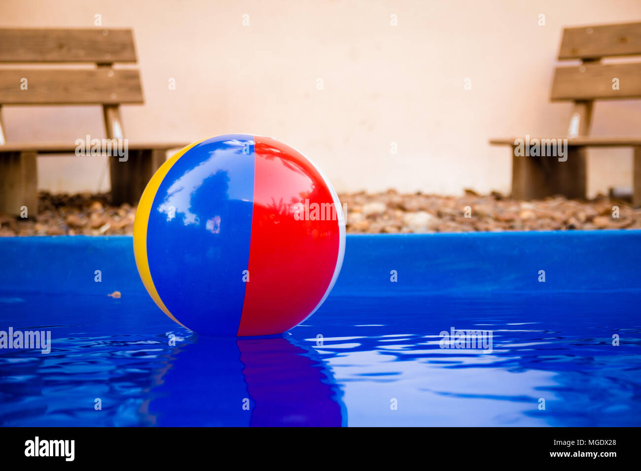 Colorful beach ball floating in pool Stock Photo - Alamy