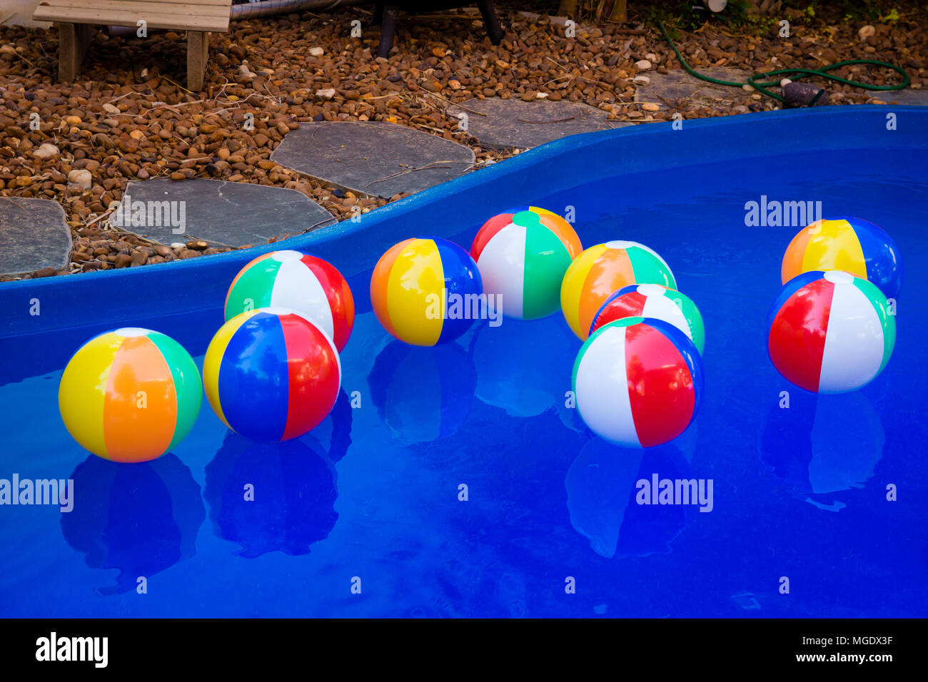 Colorful beach balls floating in pool Stock Photo - Alamy