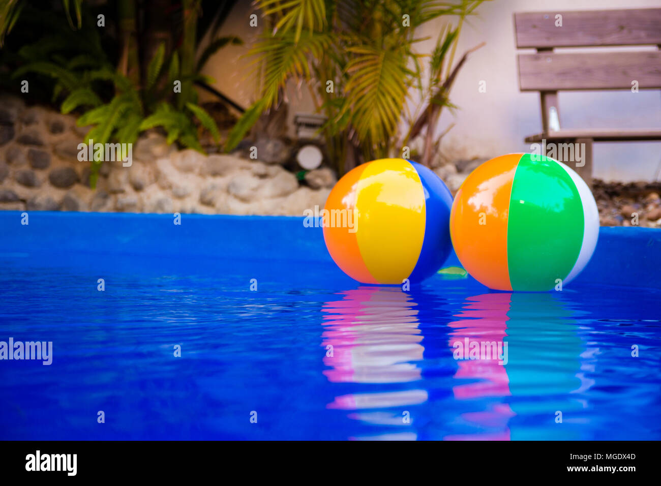 Colorful beach balls floating in pool Stock Photo - Alamy