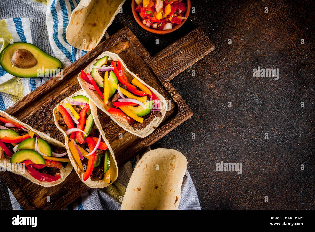 Homemade Mexican pork tacos with vegetables and salsa, on dark rusty ...