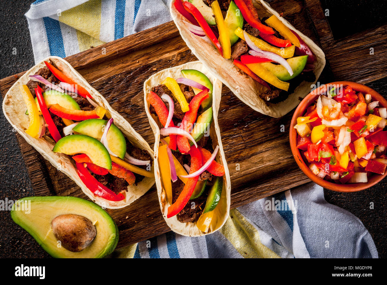 Homemade Mexican pork tacos with vegetables and salsa, on dark rusty ...