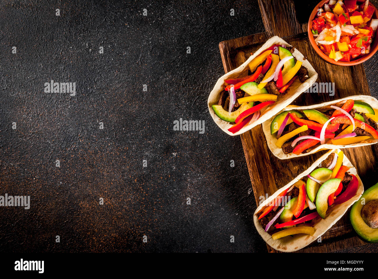 Homemade Mexican pork tacos with vegetables and salsa, on dark rusty ...