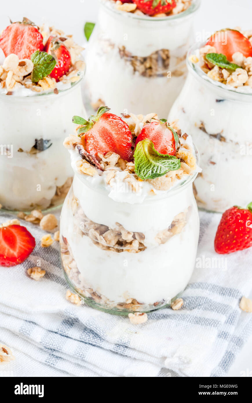 Healthy summer breakfast idea, homemade layered parfe dessert in small ...