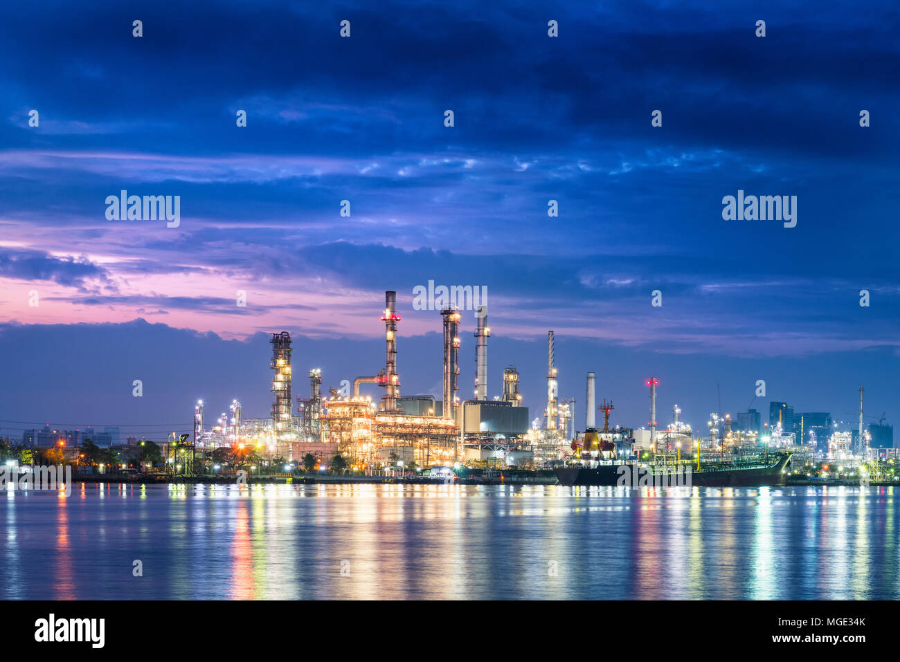 Twilight scene of oil refinery plant and cargo shipping Stock Photo - Alamy