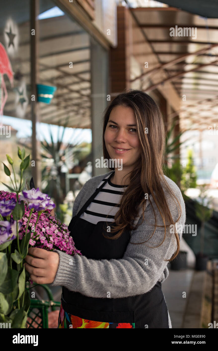 Smiling female florist wearing black apron. Vertical composition Stock ...